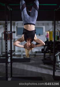 athlete woman doing abs exercises hanging upside down on horizontal bar ...