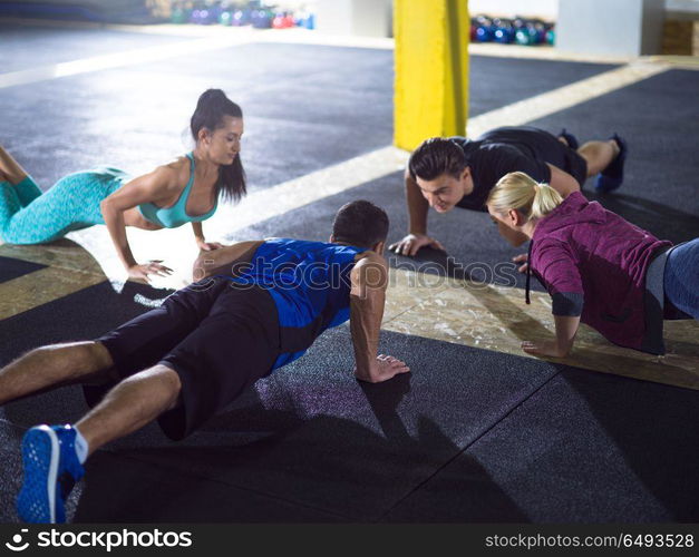 group of young healthy people doing pushups at crossfitness gym. young ...