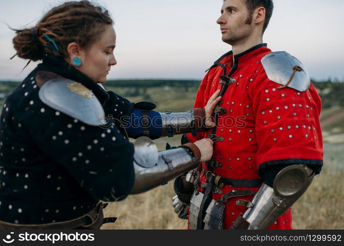 Medieval knight helps his friend to put on armor, great tournament ...