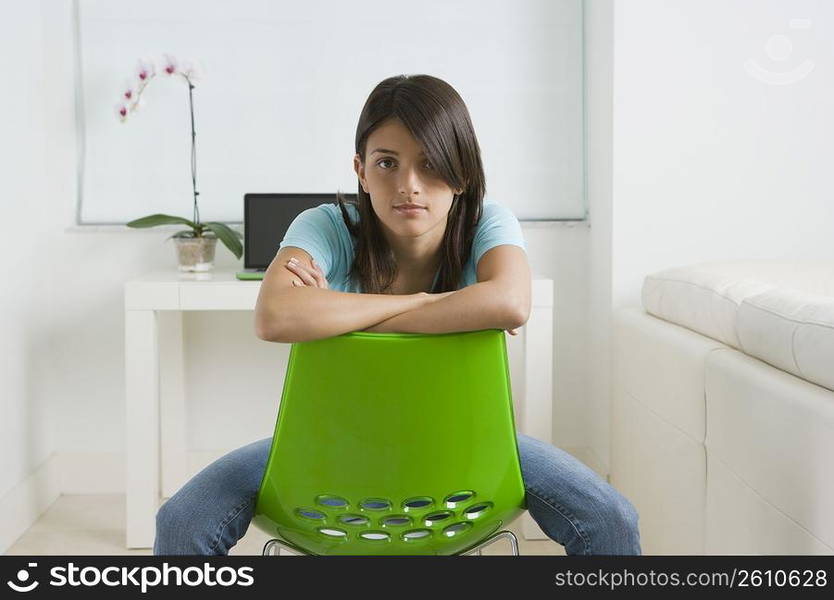 Teenage girl sitting on a chair and smiling — Stockphotos.com