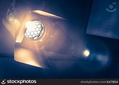 Professional orange studio spotlight hanging on the ceiling. Lighted ...