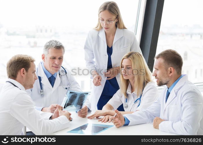Team of experts doctors examining lungs X-ray report on hospital office ...