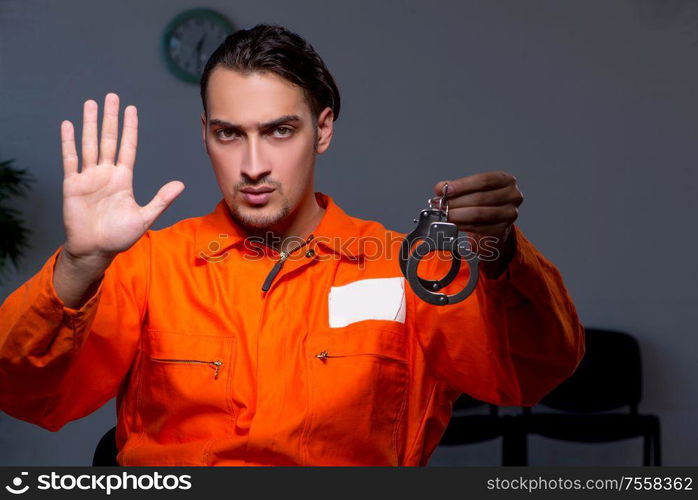 The young convict man sitting in dark room. Young convict man sitting ...