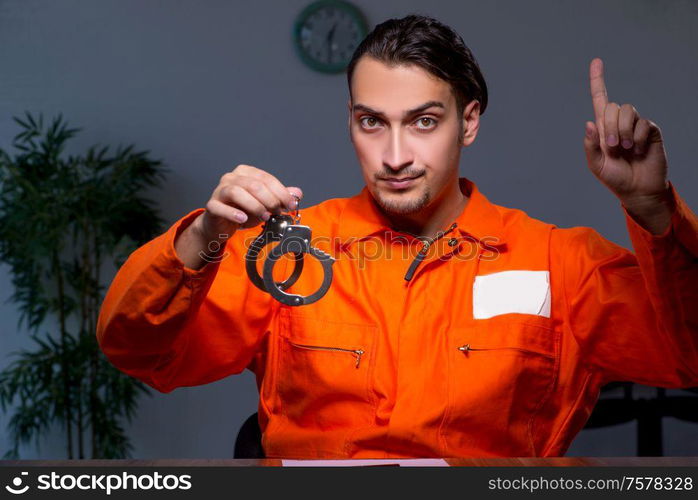 The young convict man sitting in dark room. Young convict man sitting ...